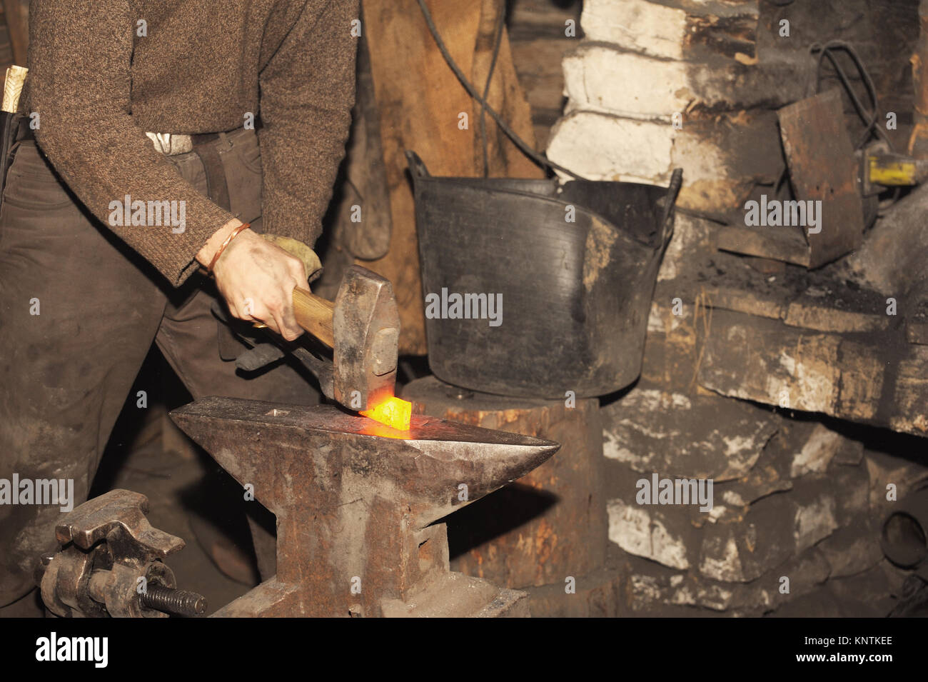 Blacksmith working in the forge processes the metal . The photograph on ...