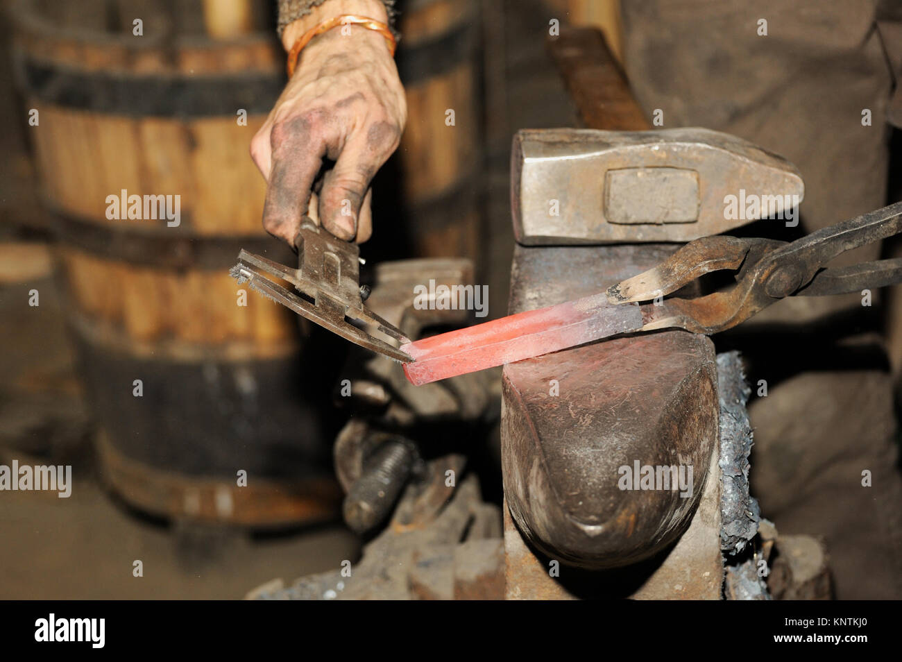 Blacksmith working in the forge processes the metal . The photograph on ...
