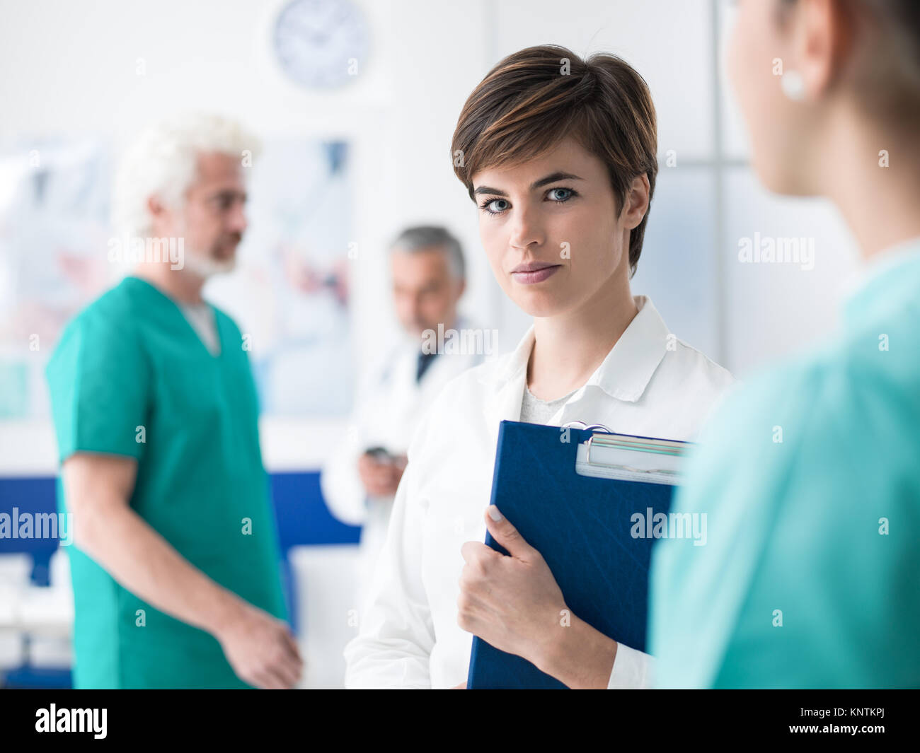 Confident young female doctor working at the hospital and medical staff ...