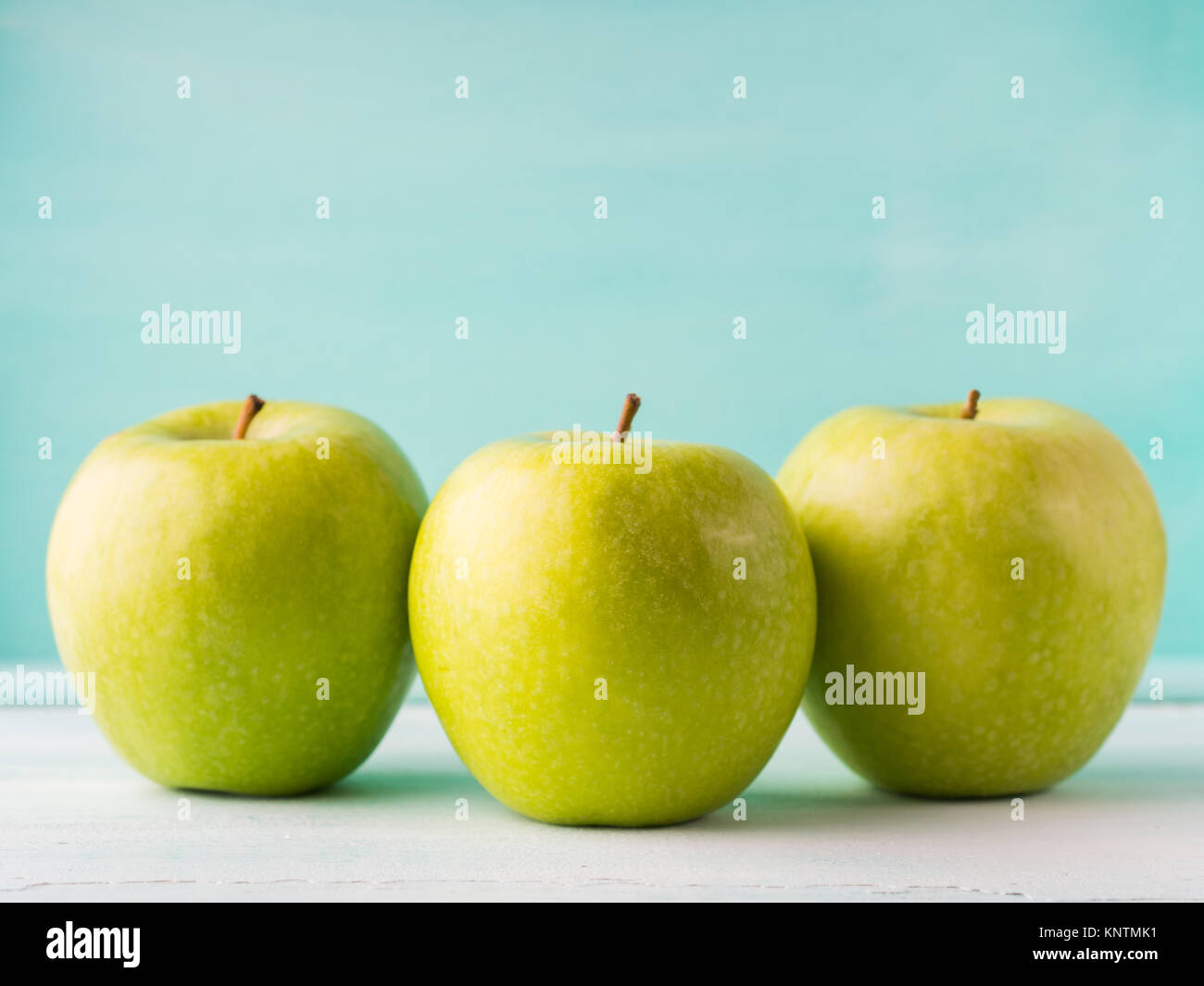 Three Green apples on turquoise background. Healthy food three pillars ...