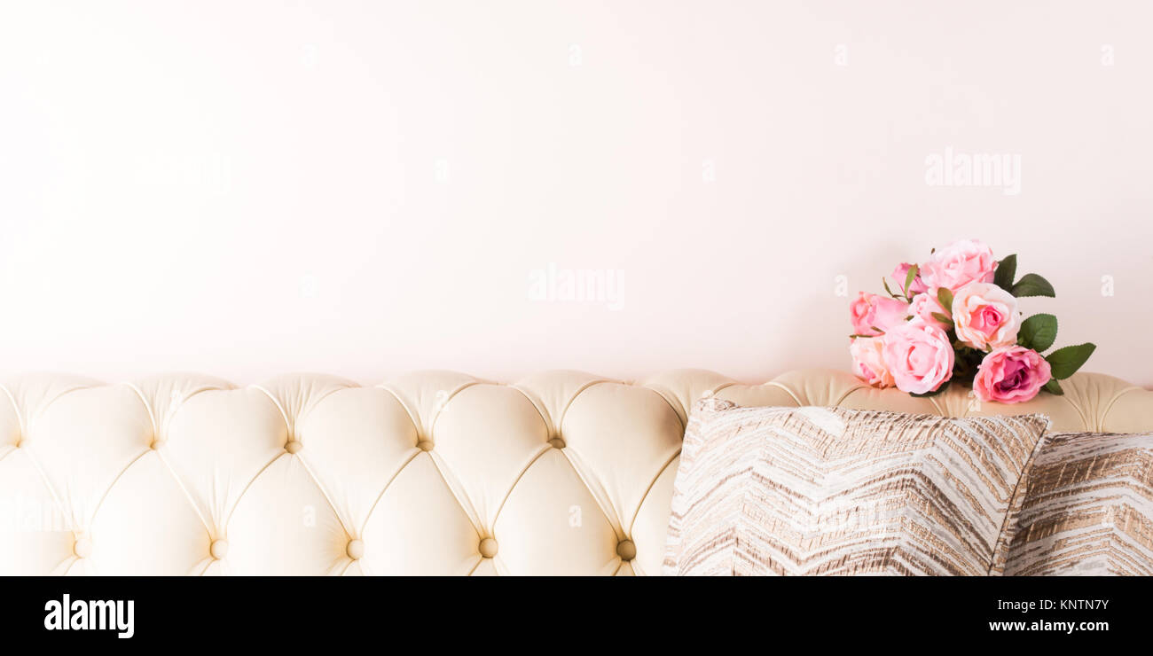 Cream white leather sofa background with pillows and flowers Stock ...