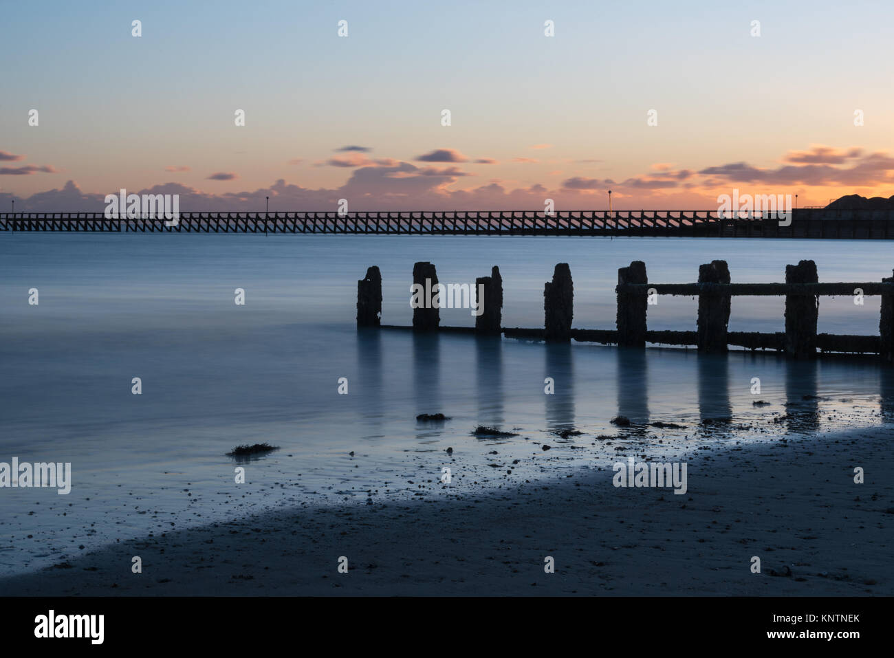 Scenic landscape view of sea defence groynes with reflections at ...
