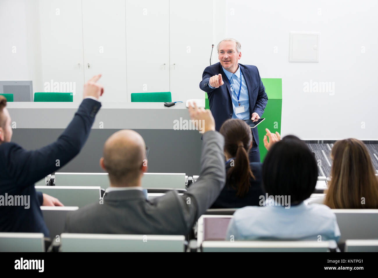 Confident senior businessman asking questions to colleagues while ...
