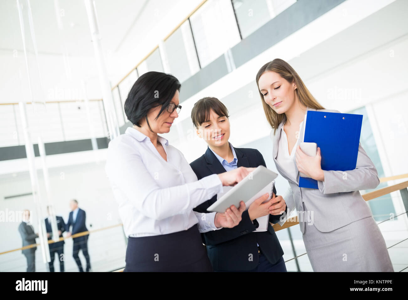 Mature female professional explaining project to colleagues on digital ...