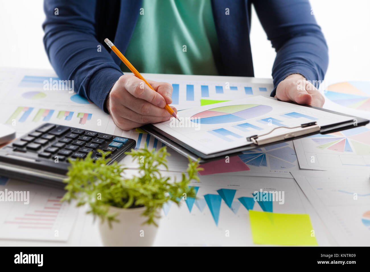 Businessman holding a pen is working with graph documents and sunset ...