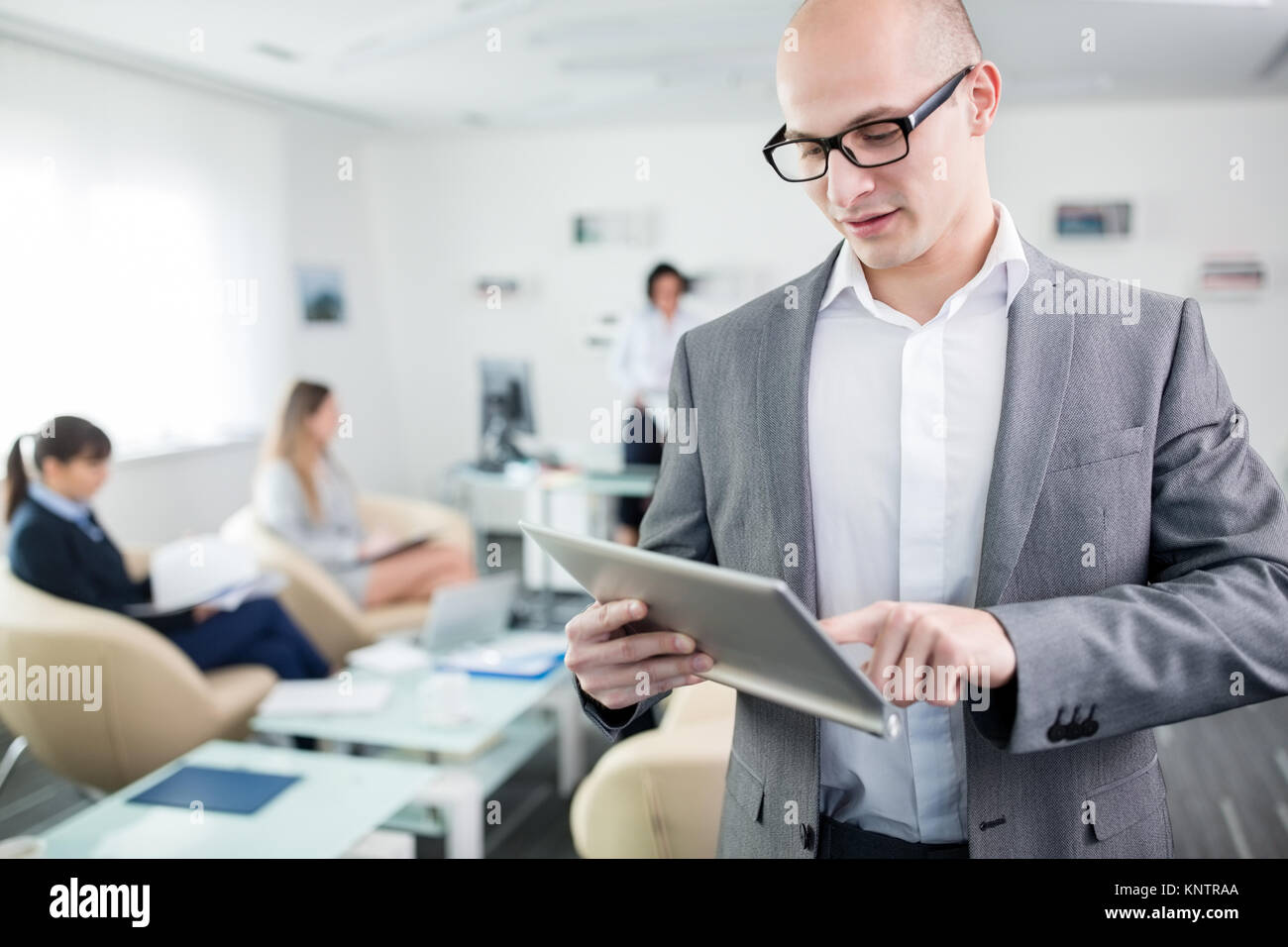 Confident businessman using tablet computer in meeting room at office ...