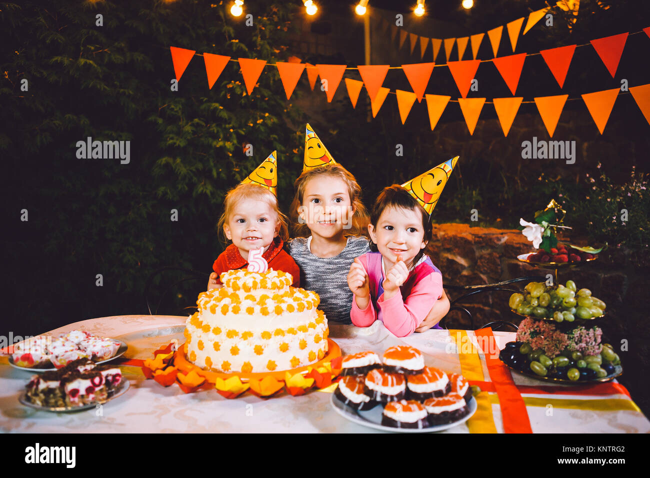 Children's birthday party. Three cheerful children girls eating cake ...
