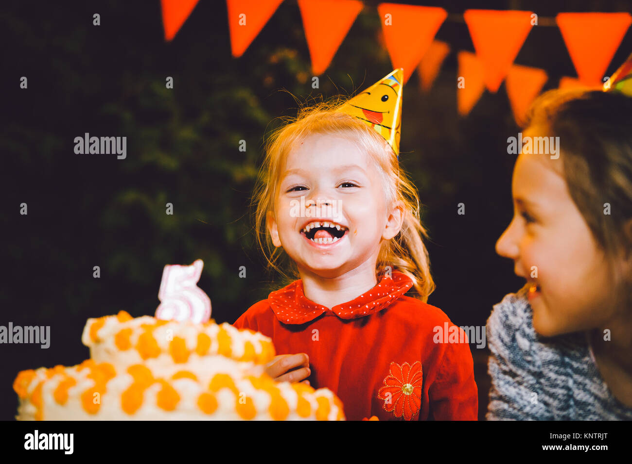Children's birthday party. Three cheerful children girls eating cake ...