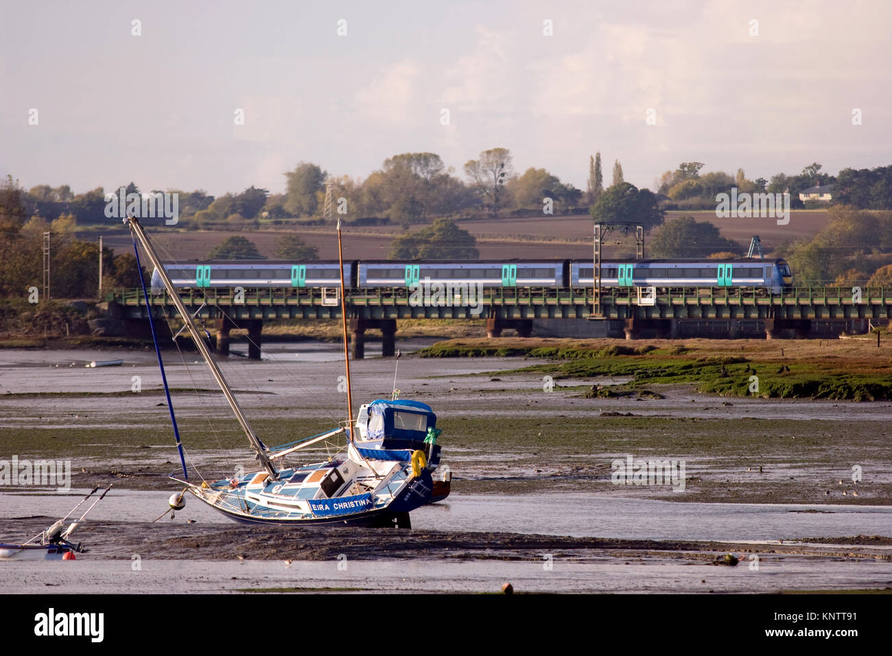 A train crossing over the mudflats of the river Stour between ...