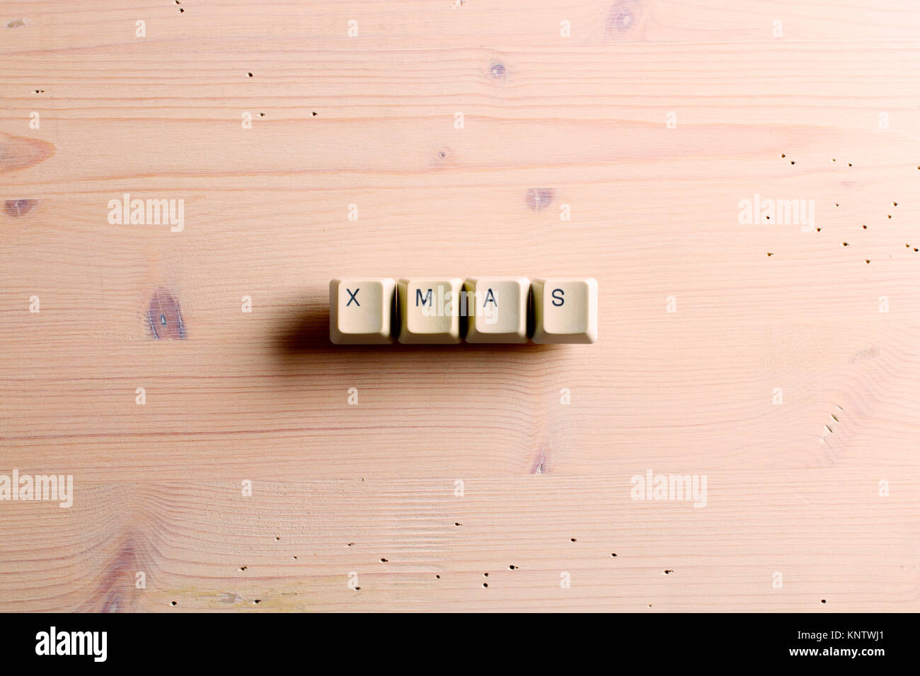 Xmas word. Flat lay view from above on the table with computer keyboard keys buttons on a wooden ...