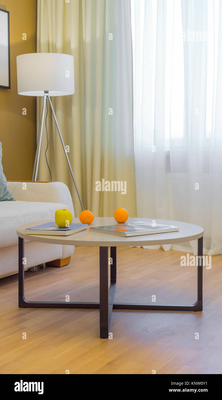 Journal table with oranges in the living interior Stock Photo - Alamy