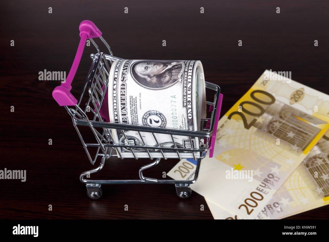 Stack of dollar and euro banknotes with shopping cart in money ...