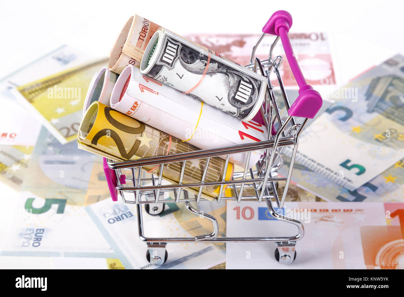 Stack of Euro banknotes with shopping cart in money consuming concept ...