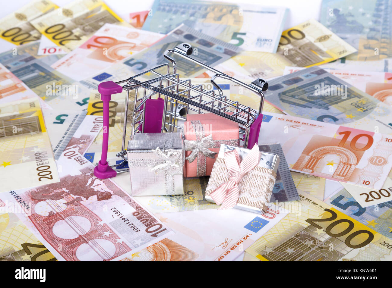 Stack of Euro banknotes with shopping cart and gift boxes in money ...