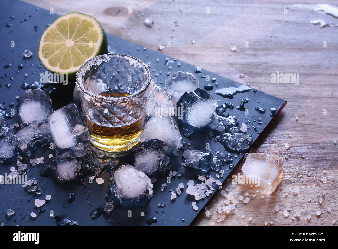Alcoholic strong drinks in piles on the background and pieces of lime ...