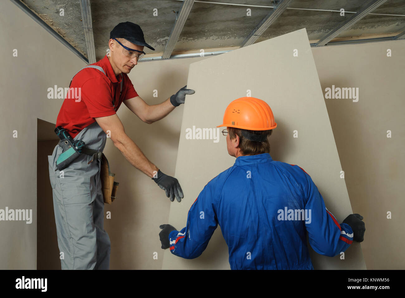 Drywall Installers. Men holding a gypsum board figured cut Stock Photo ...