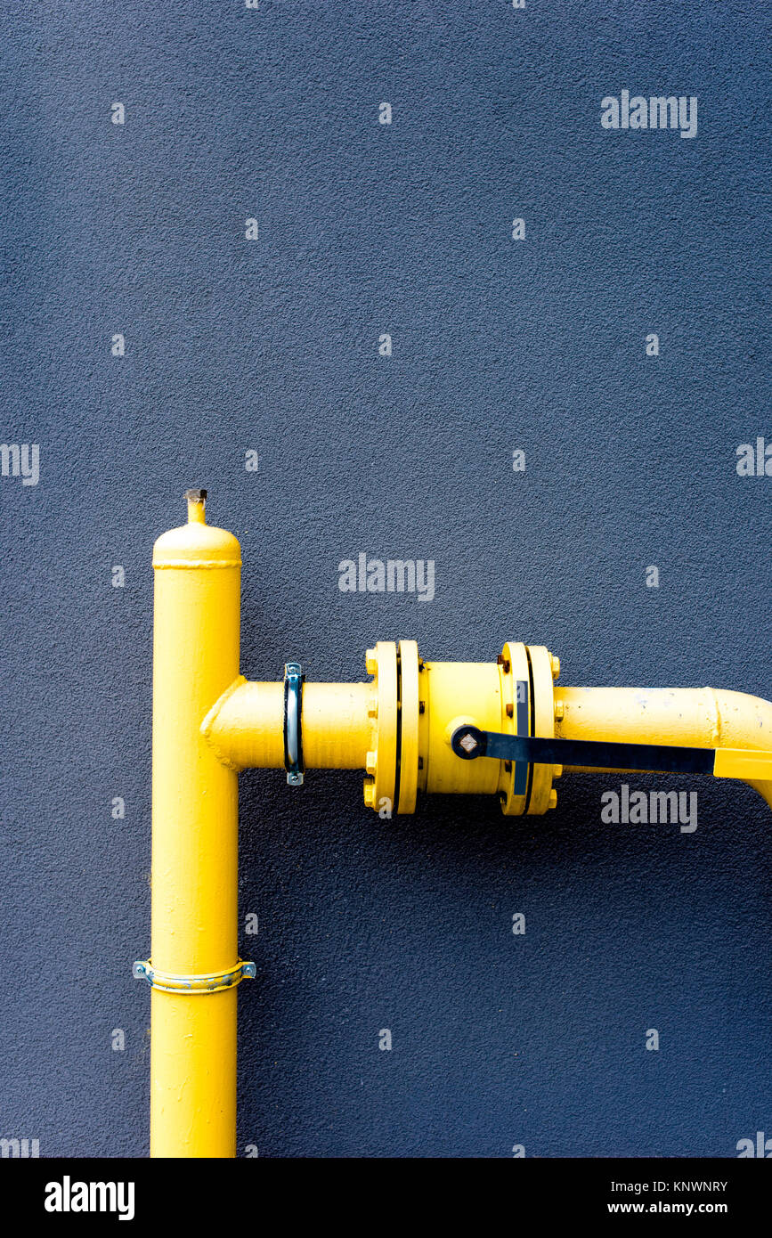 Yellow gas pipe and blue wall Stock Photo - Alamy