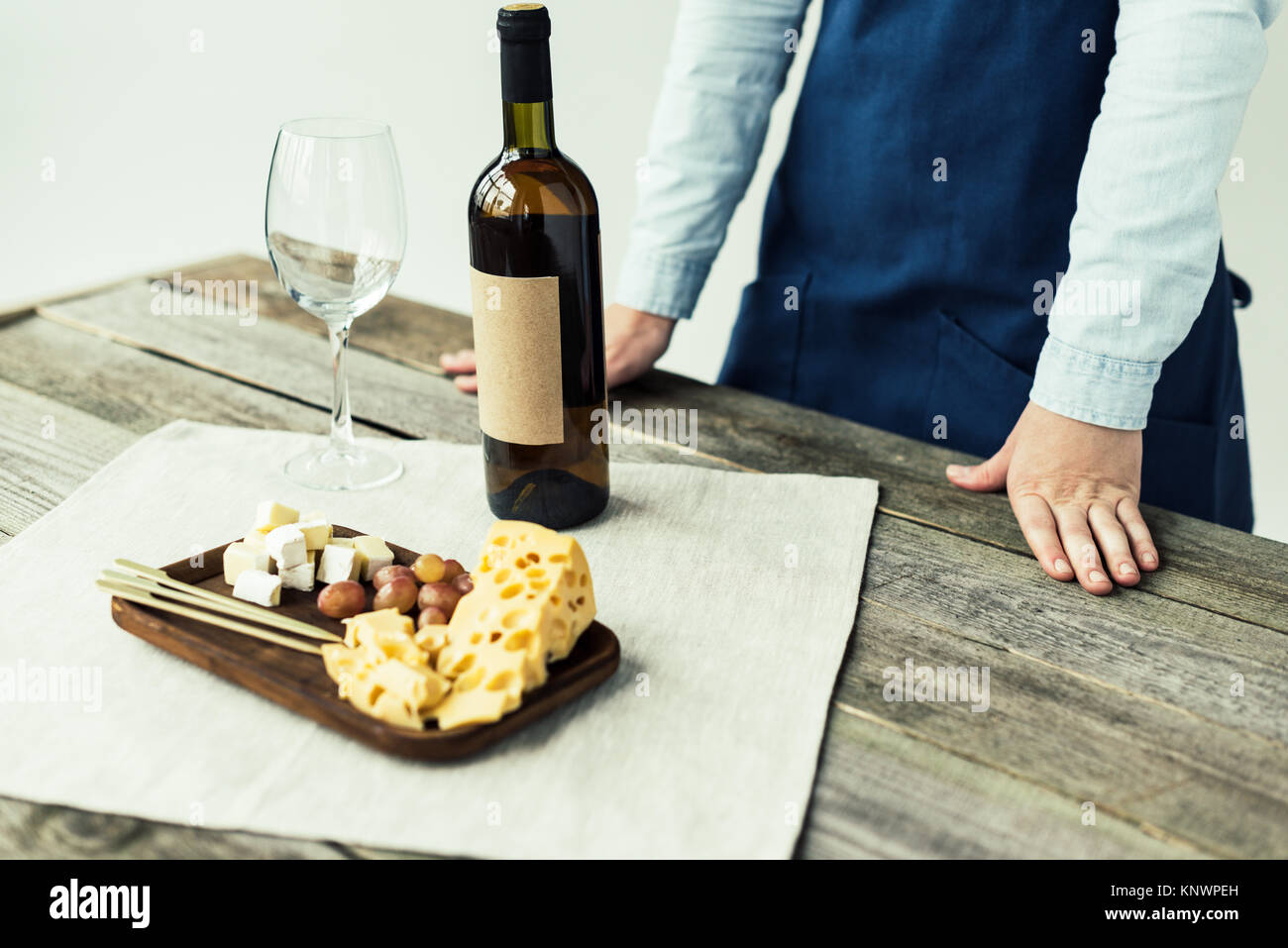 sommelier standing at table with wine bottle Stock Photo - Alamy