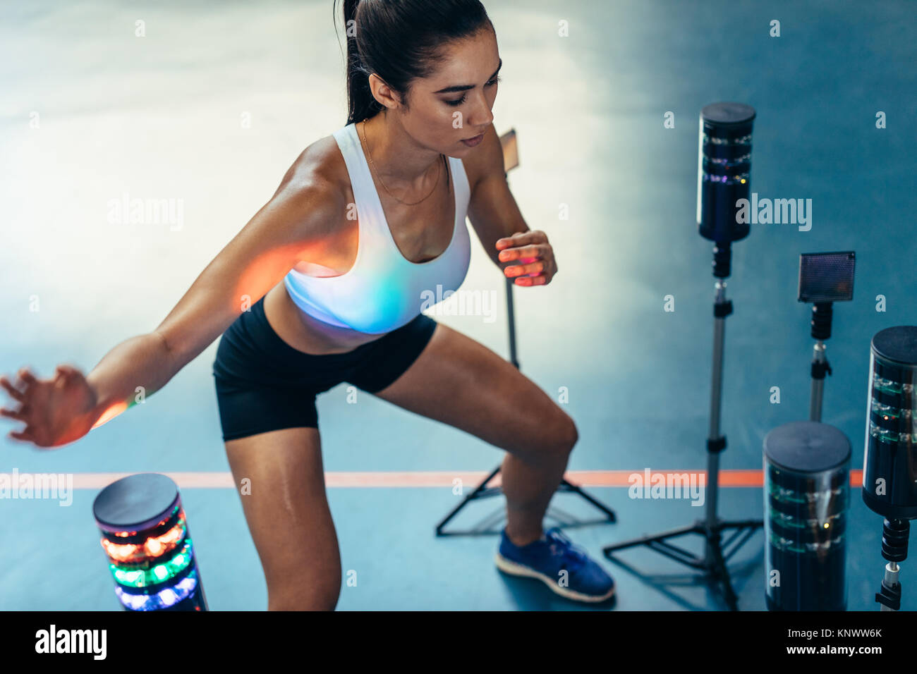 Woman doing hand eye reaction training with lights sensors in sports ...