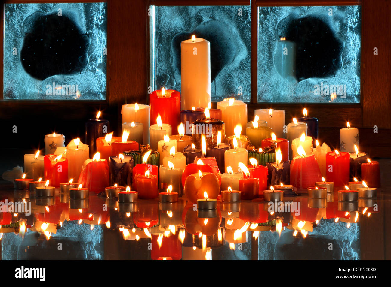 many burning candles in front of an iced window Stock Photo - Alamy