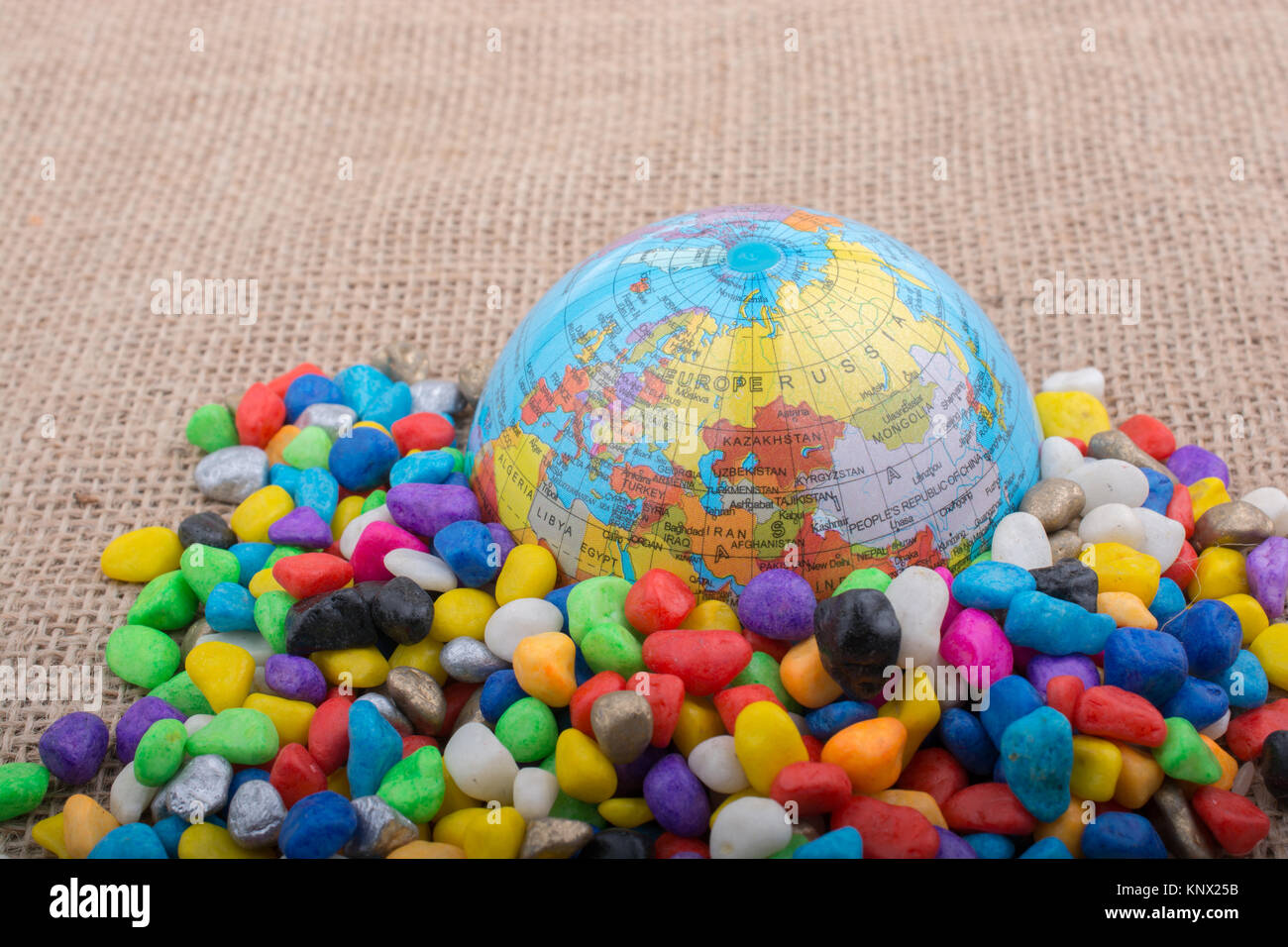 Model globe placed amid colorful pebbles Stock Photo - Alamy