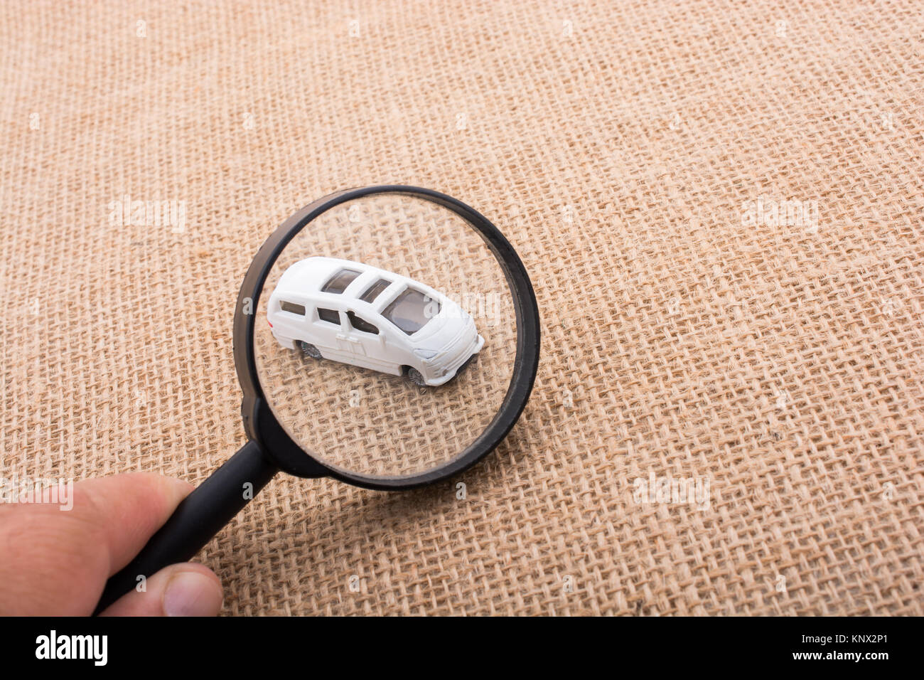 Toy car behind a magnifying glass Stock Photo - Alamy