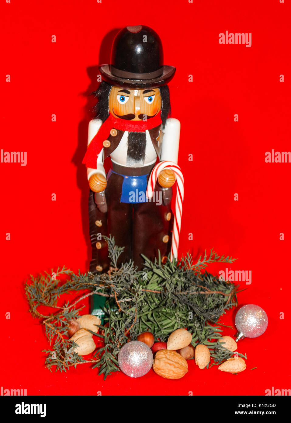 Cowboy nutcracker with hat chaps and candy cane standing in greenery ...