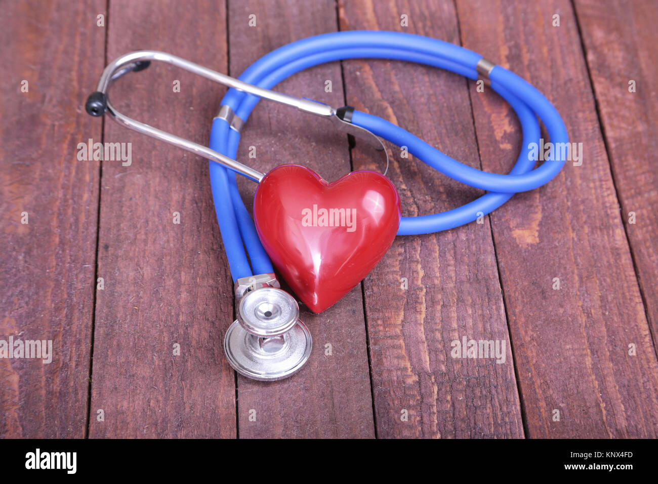 Heart with a stethoscope, isolated on wooden background Stock Photo - Alamy