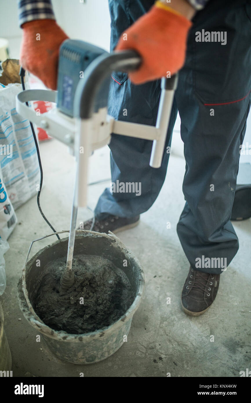 Mixing of a plaster solution by an electric drill. Home renovation ...