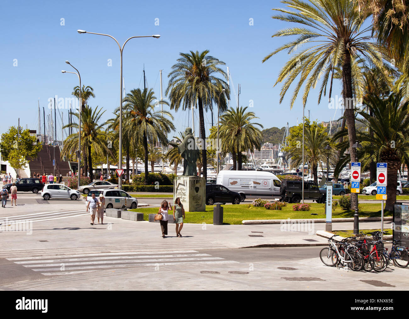 View of city town of Palma de Mallorca. People cross street. Palm trees ...