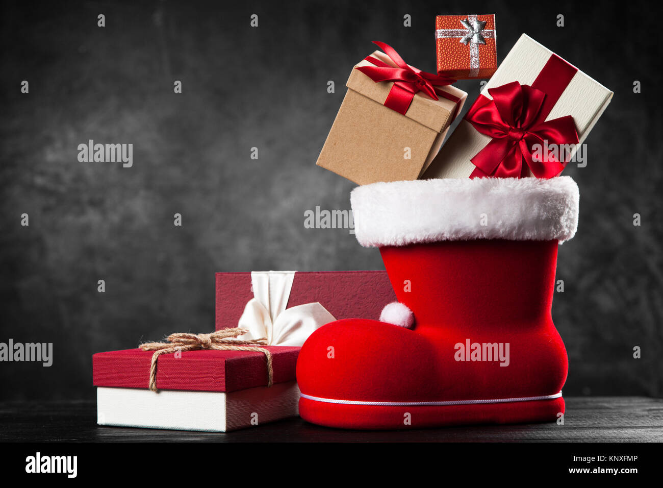 Santa's shoe with gifts boxes on dark background Stock Photo - Alamy