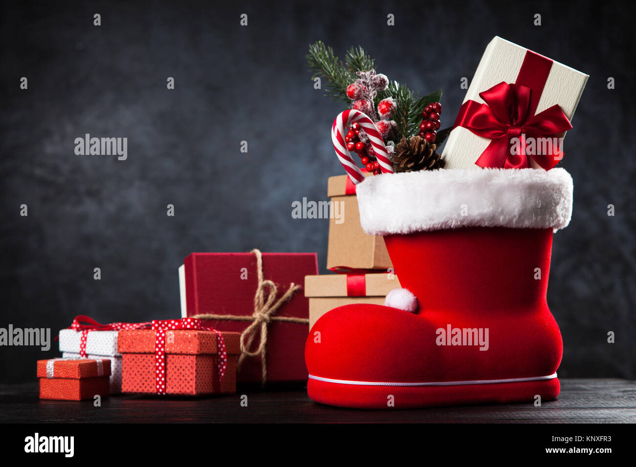 Santa's shoe with gifts boxes on dark background Stock Photo - Alamy