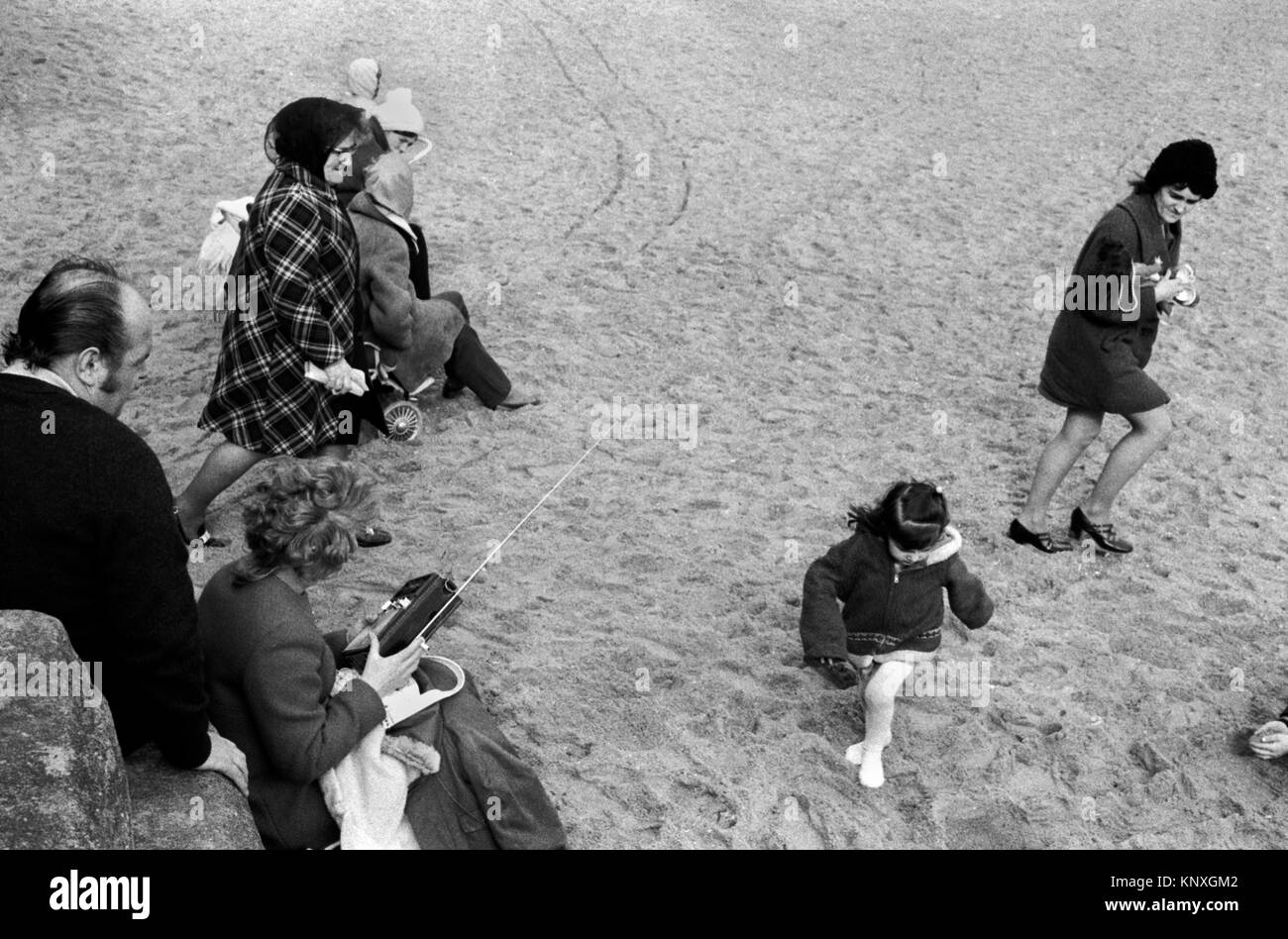 Families on beach woman with old fashioned large transistor radio 1970s ...