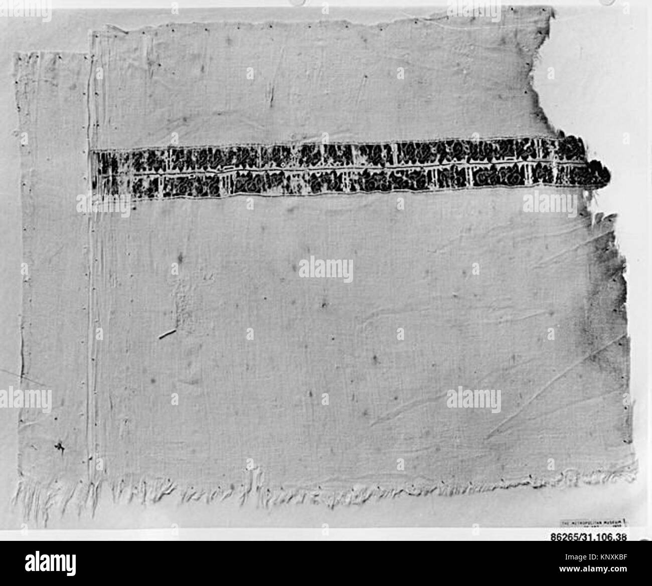 A fragment of an ancient manuscript or textile, preserved and cataloged ...