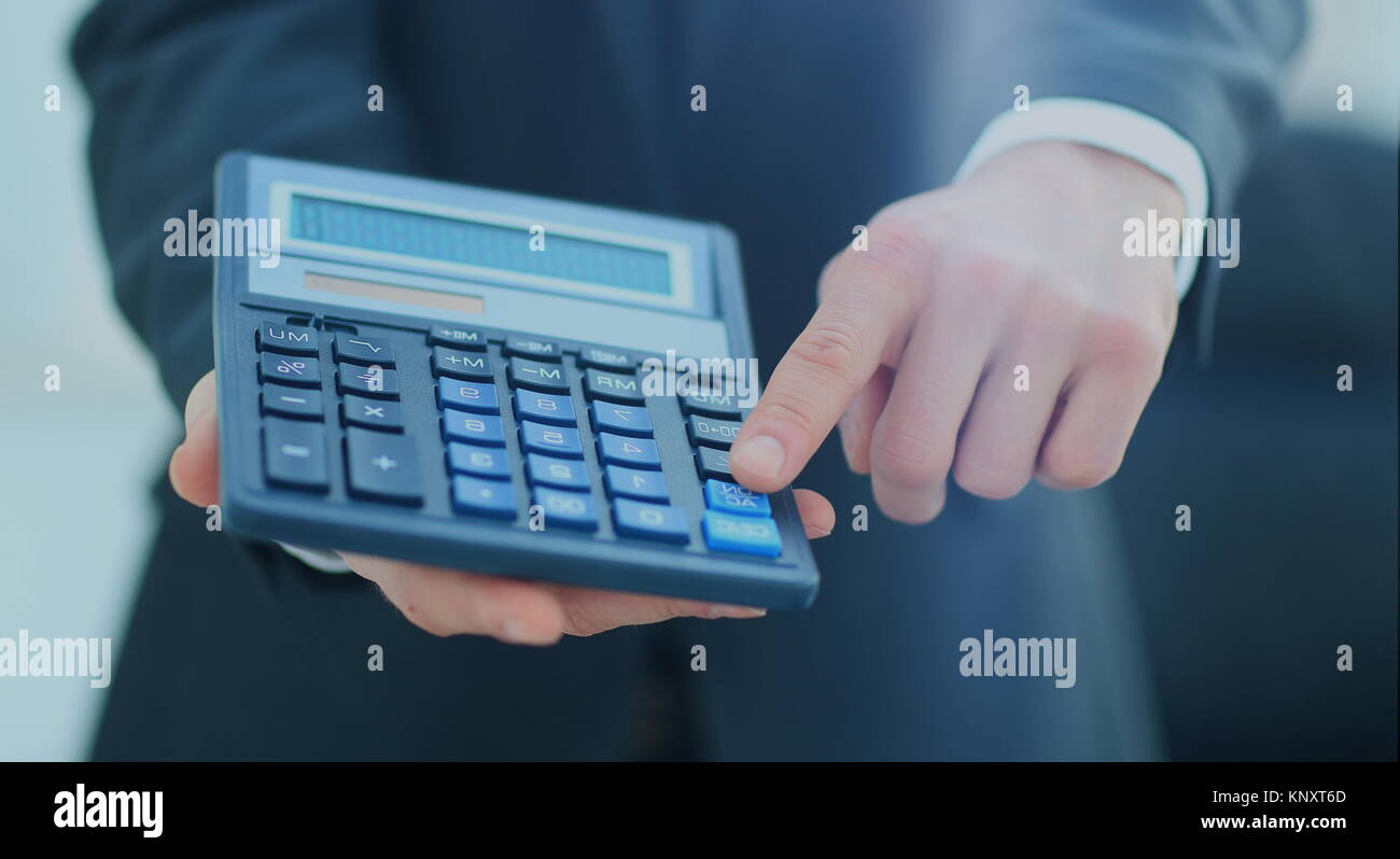 Businessman holding calculator Stock Photo - Alamy
