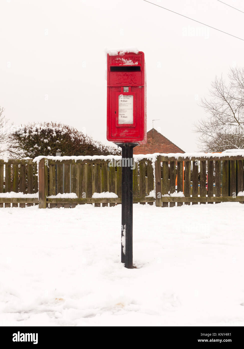 red village post box outside street village with snow winter; essex ...
