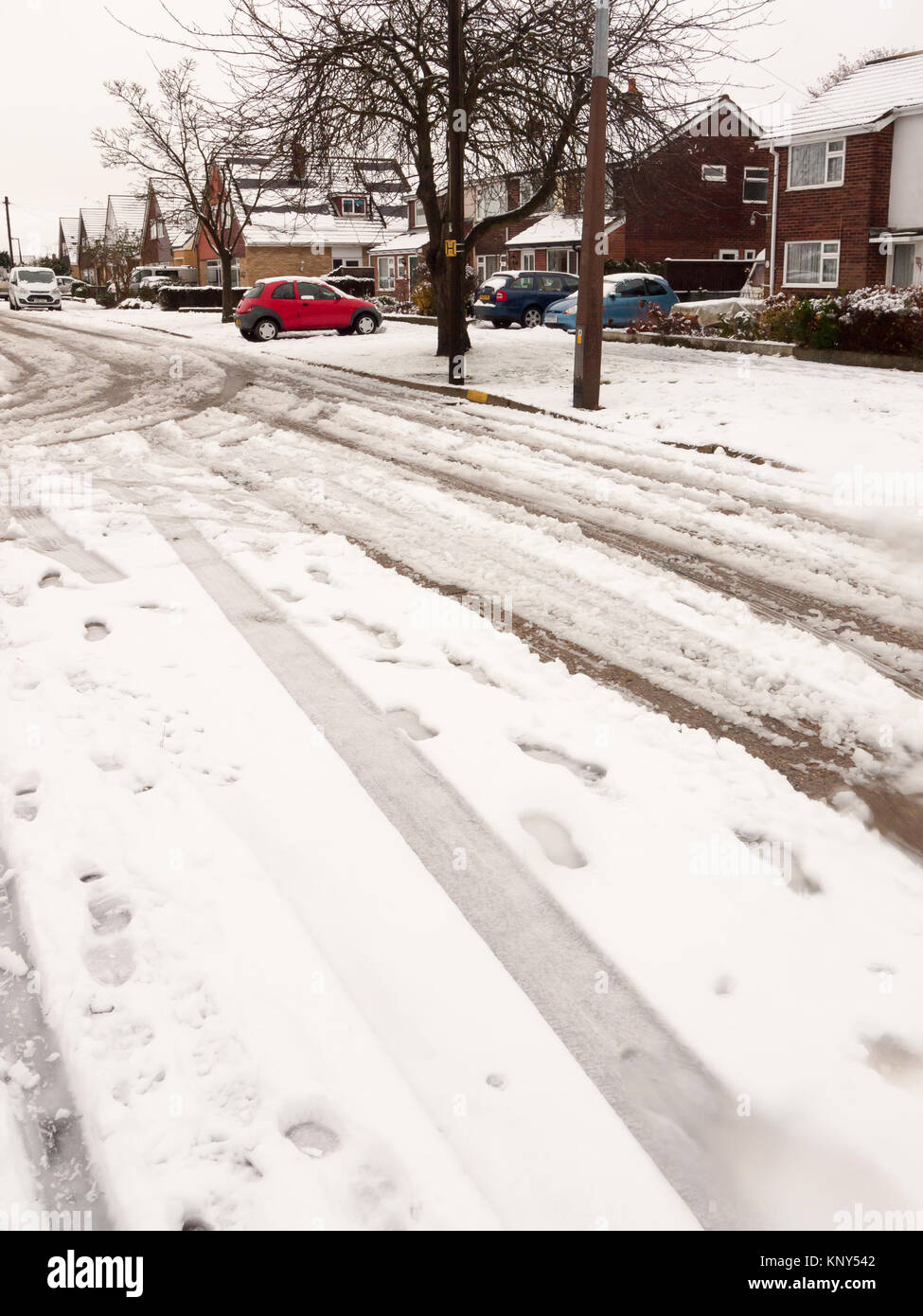 snow covered street road with tire tracks leading through village ...