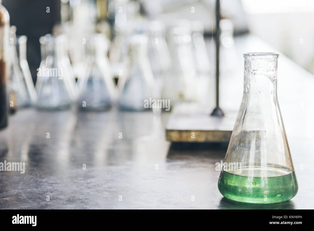 detail shot of beakers and equipment on table in factory laboratory ...
