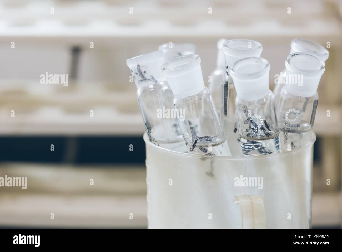 detail shot of beakers and equipment on table in factory laboratory ...