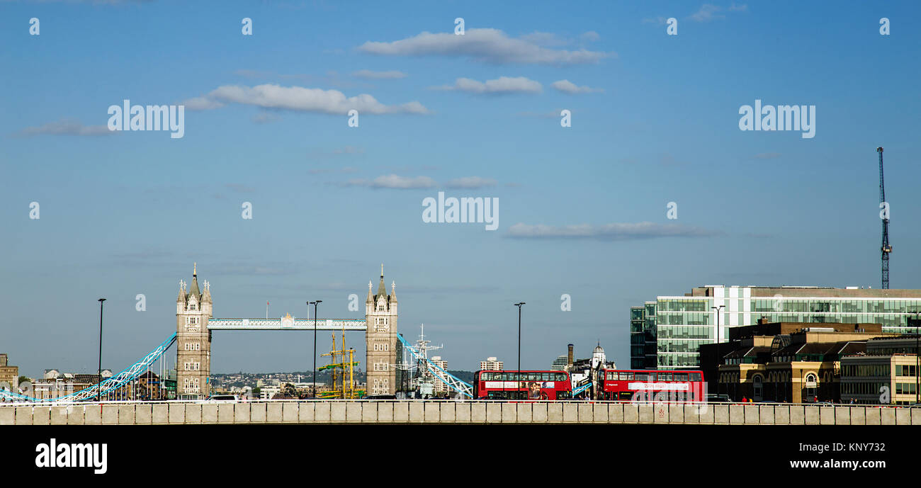 Side view of London Tower Bridge with 2 double decker red buses driving ...