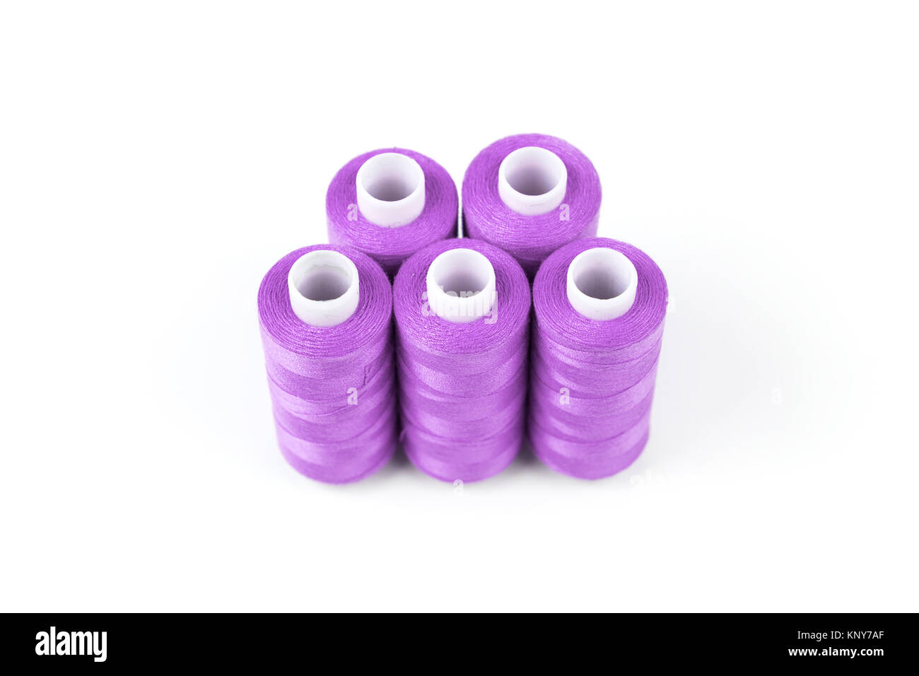 Five violet purple sewing threads on a white background, sewing and ...