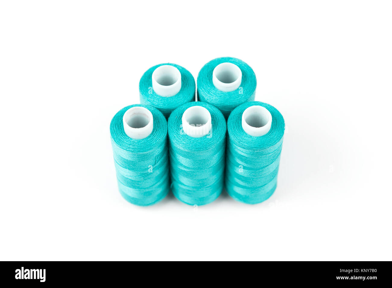 Five turquoise sewing threads on a white background, sewing accessories ...