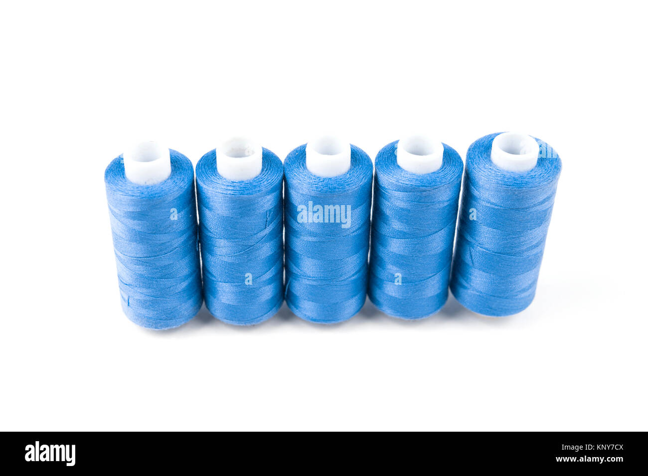 Five blue sewing threads on a white coils on a white background. Sewing ...
