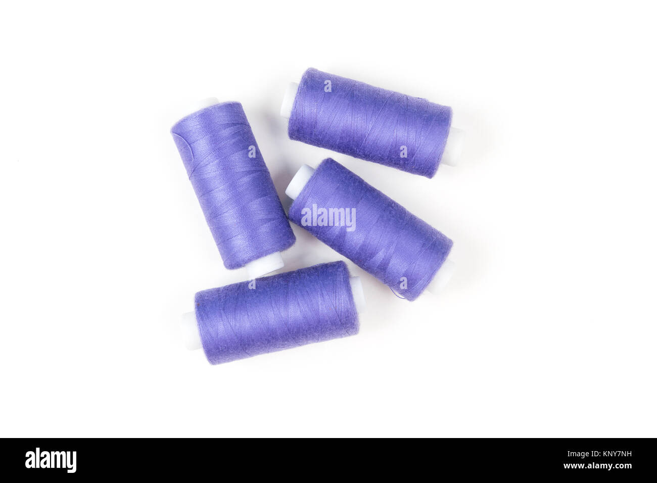 Four purple sewing threads on a white background Stock Photo - Alamy