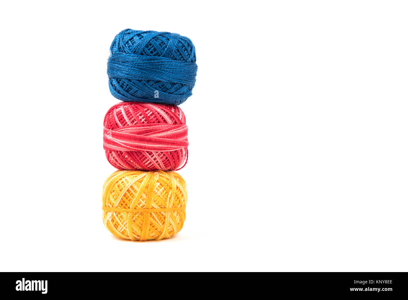 Three colored sewing threads in a row on a white background. Blue, red ...
