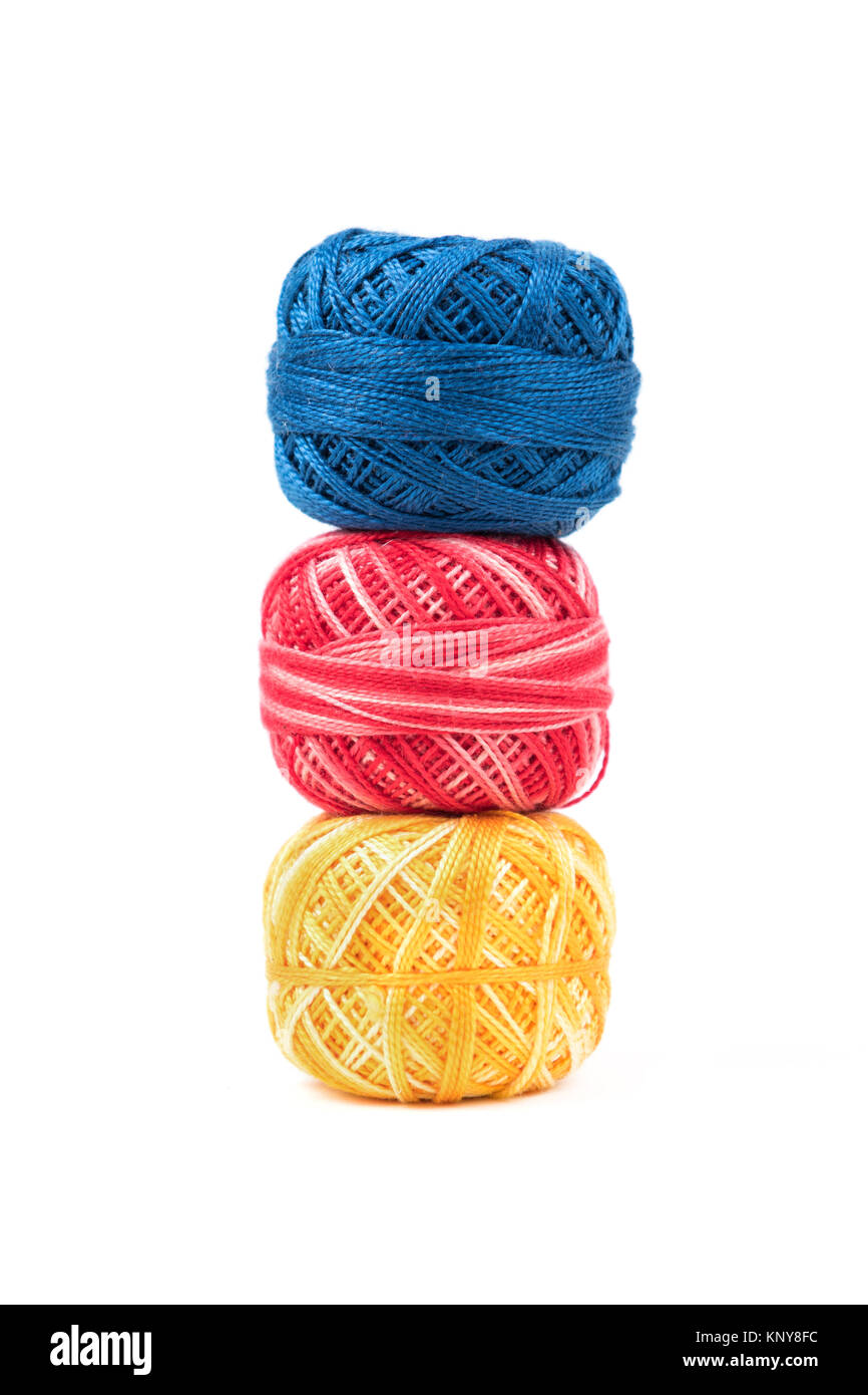 Three colored sewing threads in a row on a white background. Blue, red ...