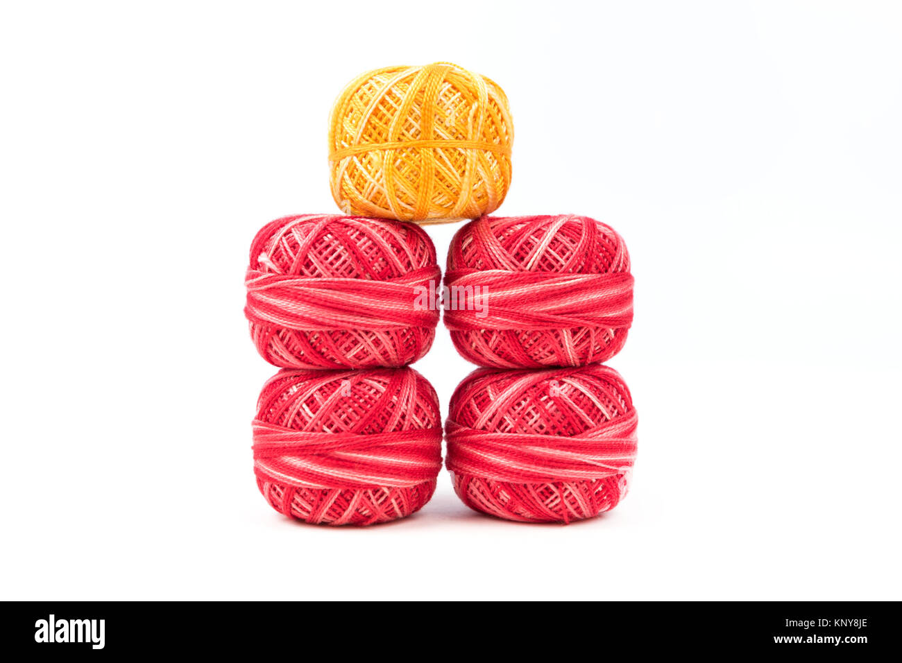 Five colored sewing threads in a row on a white background. Red and ...