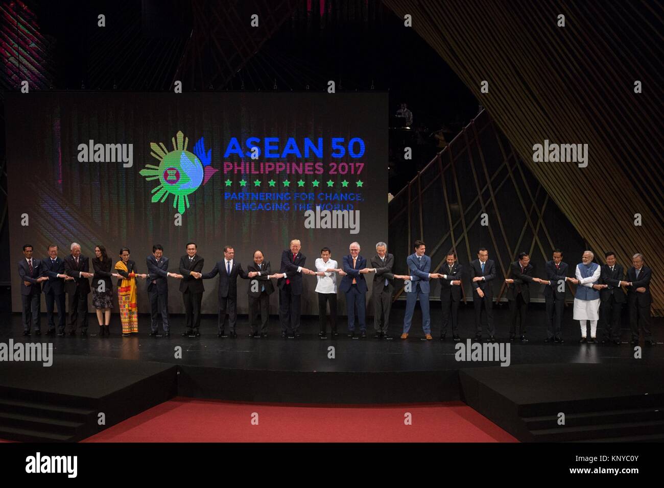 U.S. President Donald Trump, center, holds hands with Philippine ...