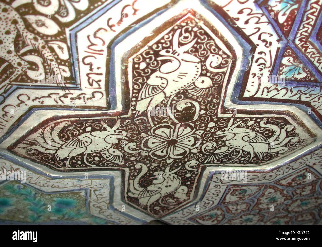 Decorative ceramic cross-shaped tile with geometric motifs and raised ...