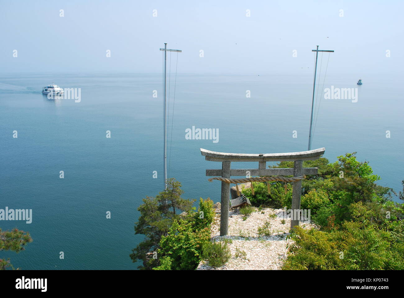 Majestic torii gate of a shrine overlooking the ocean with ships ...